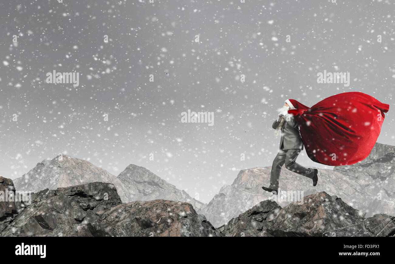 Businessman in Santa hat running with bag on back Stock Photo - Alamy