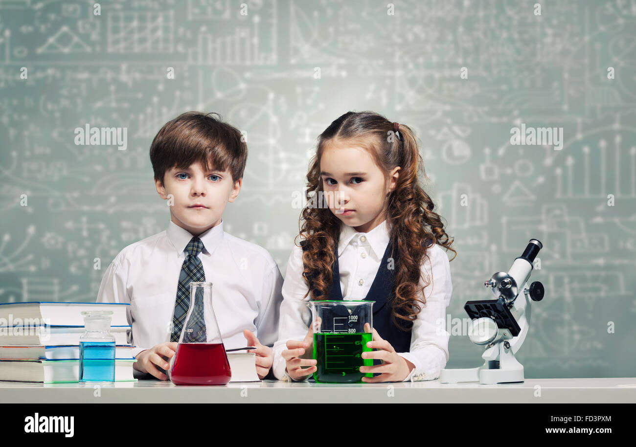 Two cute children at chemistry lesson making experiments Stock Photo ...