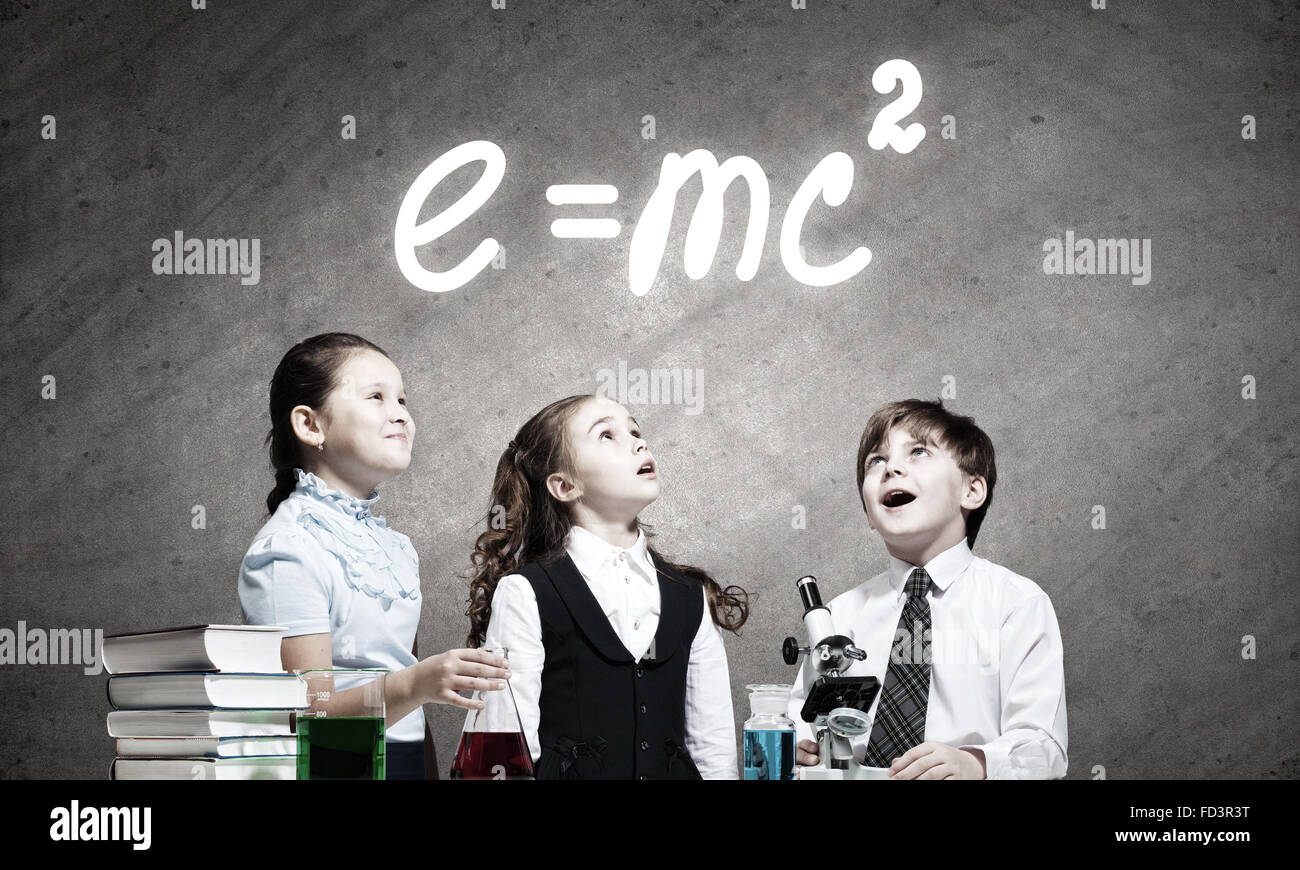 Three cute children at chemistry lesson making experiments Stock Photo ...