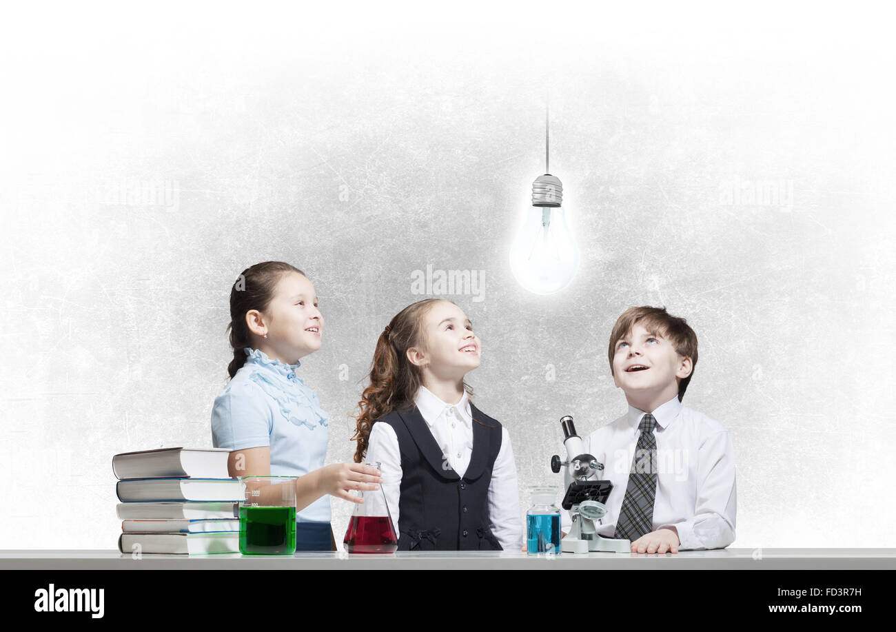 Three cute children at chemistry lesson making experiments Stock Photo ...