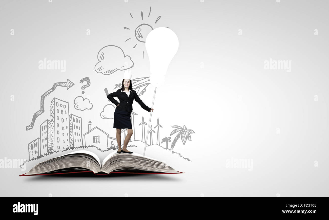 Young businesswoman in paper crown standing on book Stock Photo - Alamy