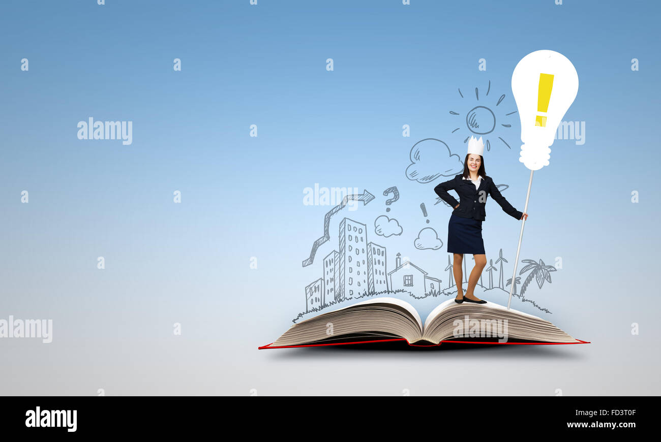 Young businesswoman in paper crown standing on book Stock Photo - Alamy