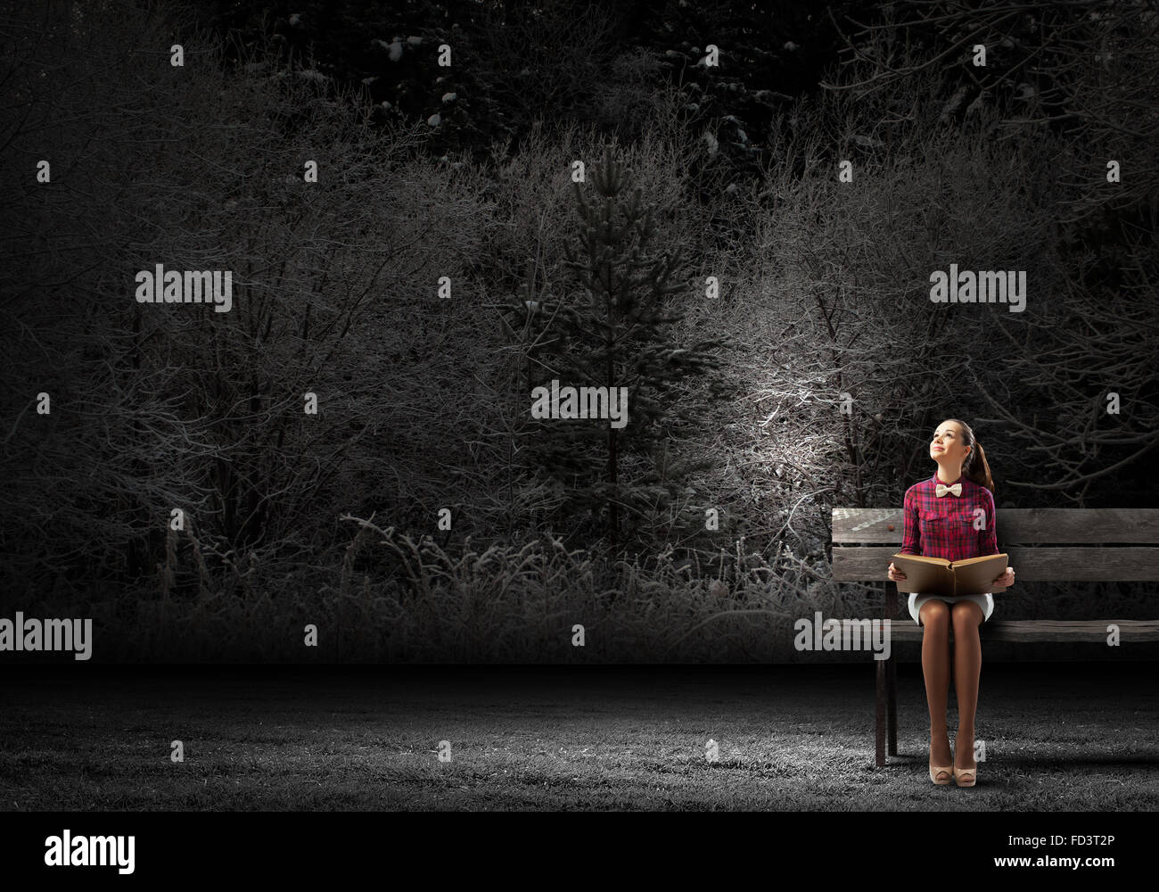 Young beautiful lady sitting on bench and reading book Stock Photo - Alamy
