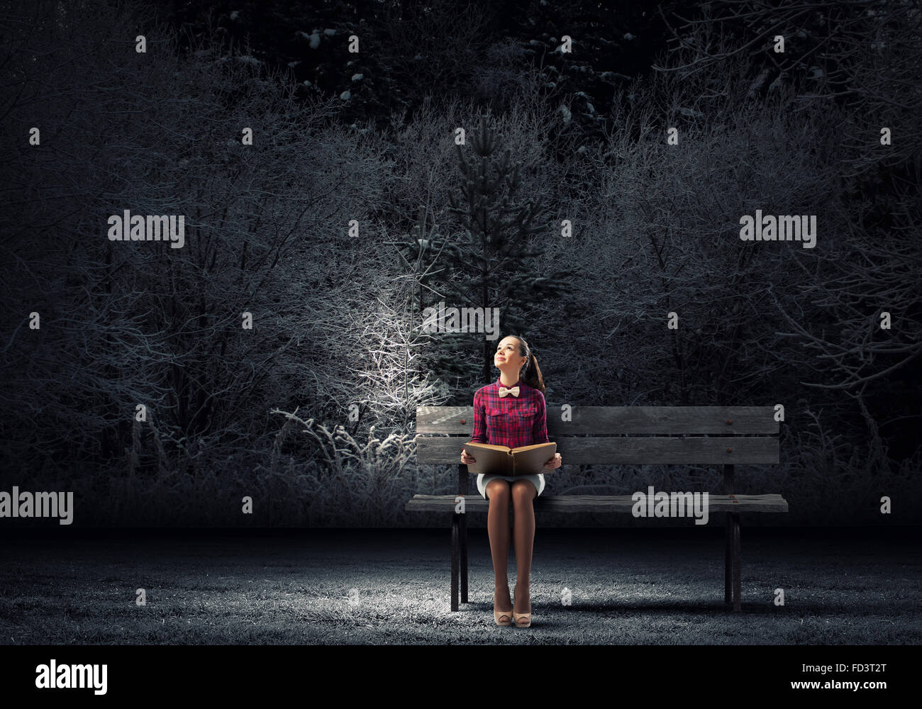 Young beautiful lady sitting on bench and reading book Stock Photo - Alamy