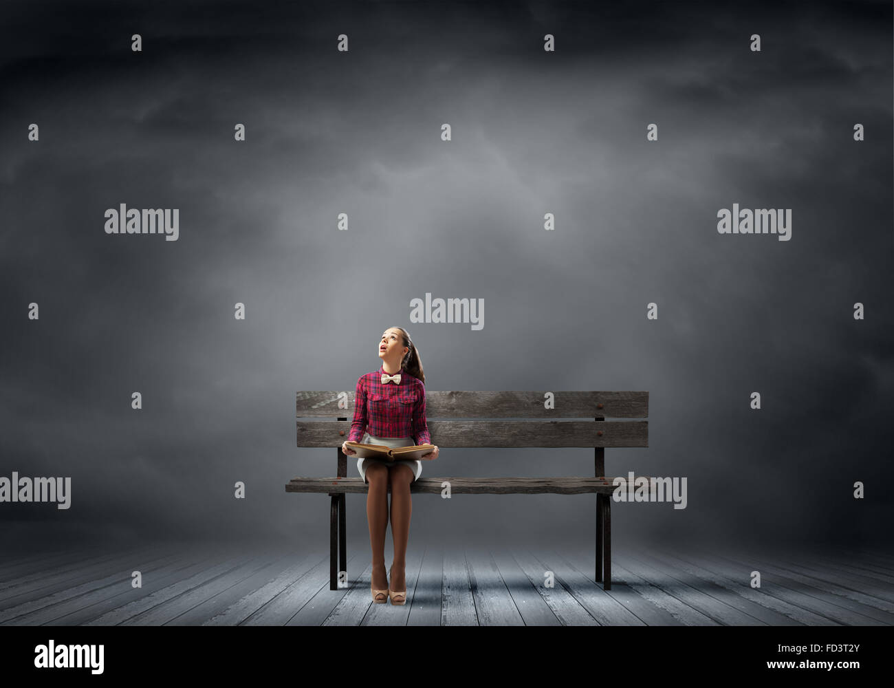 Young beautiful lady sitting on bench and reading book Stock Photo - Alamy