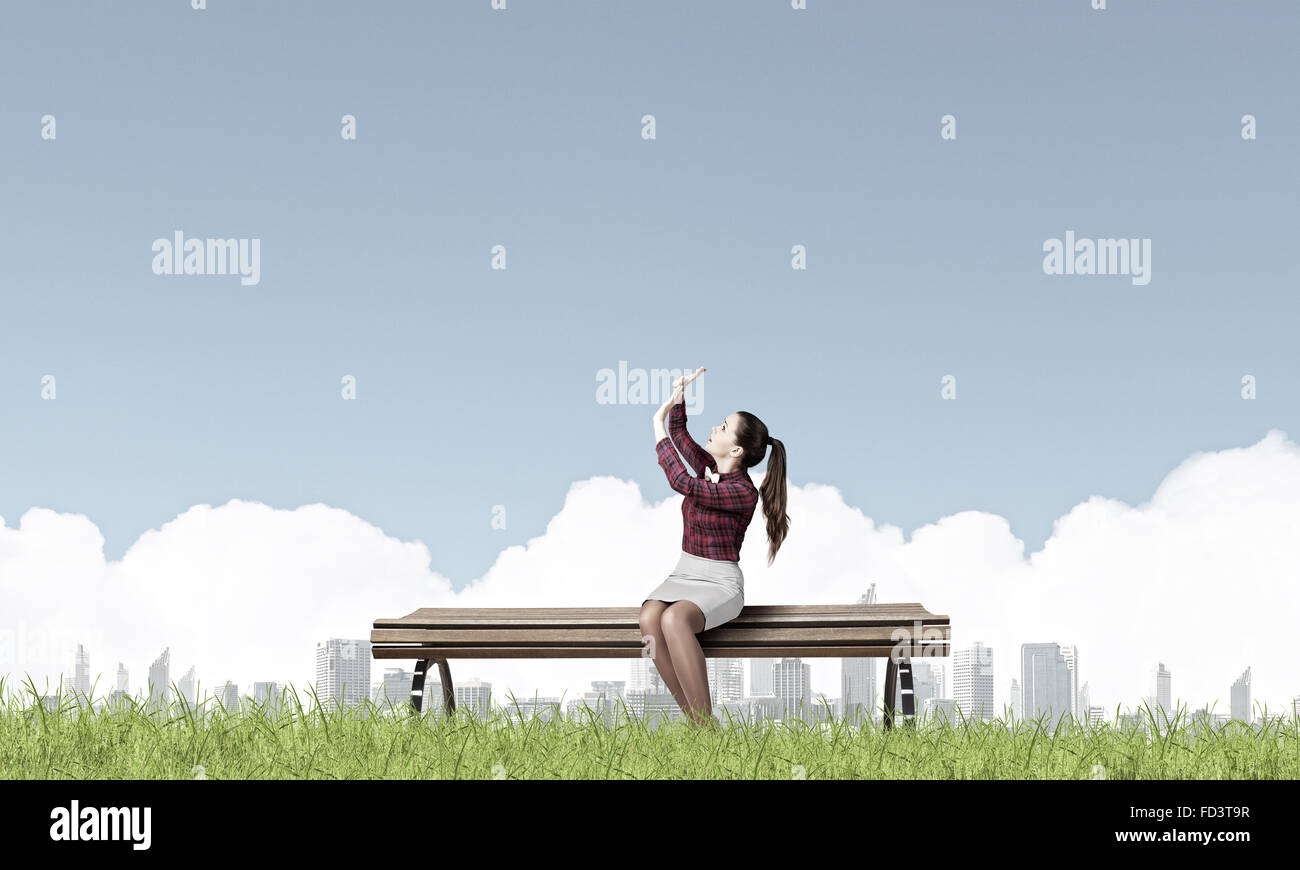 Young woman sitting on bench afraid of something Stock Photo - Alamy