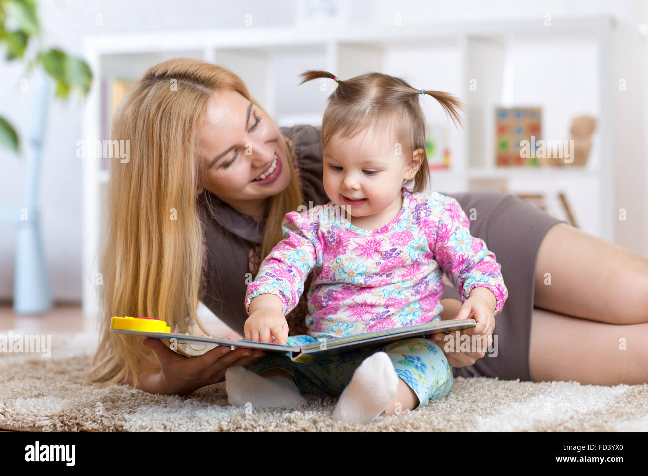 Woman and little girl watching a baby booklet Stock Photo - Alamy
