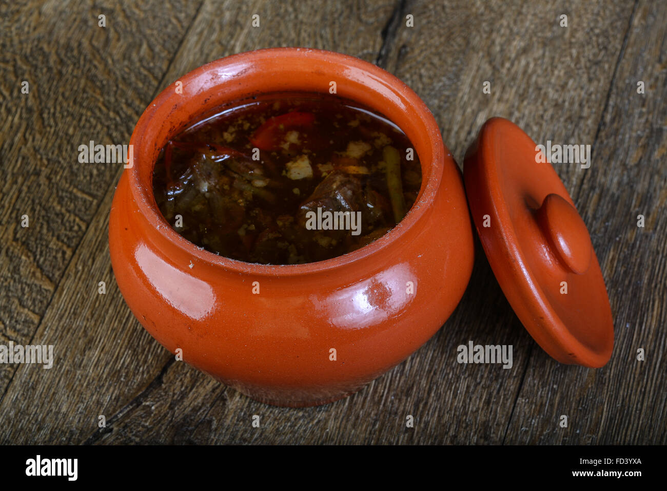 Soup in the pot on wood background Stock Photo - Alamy
