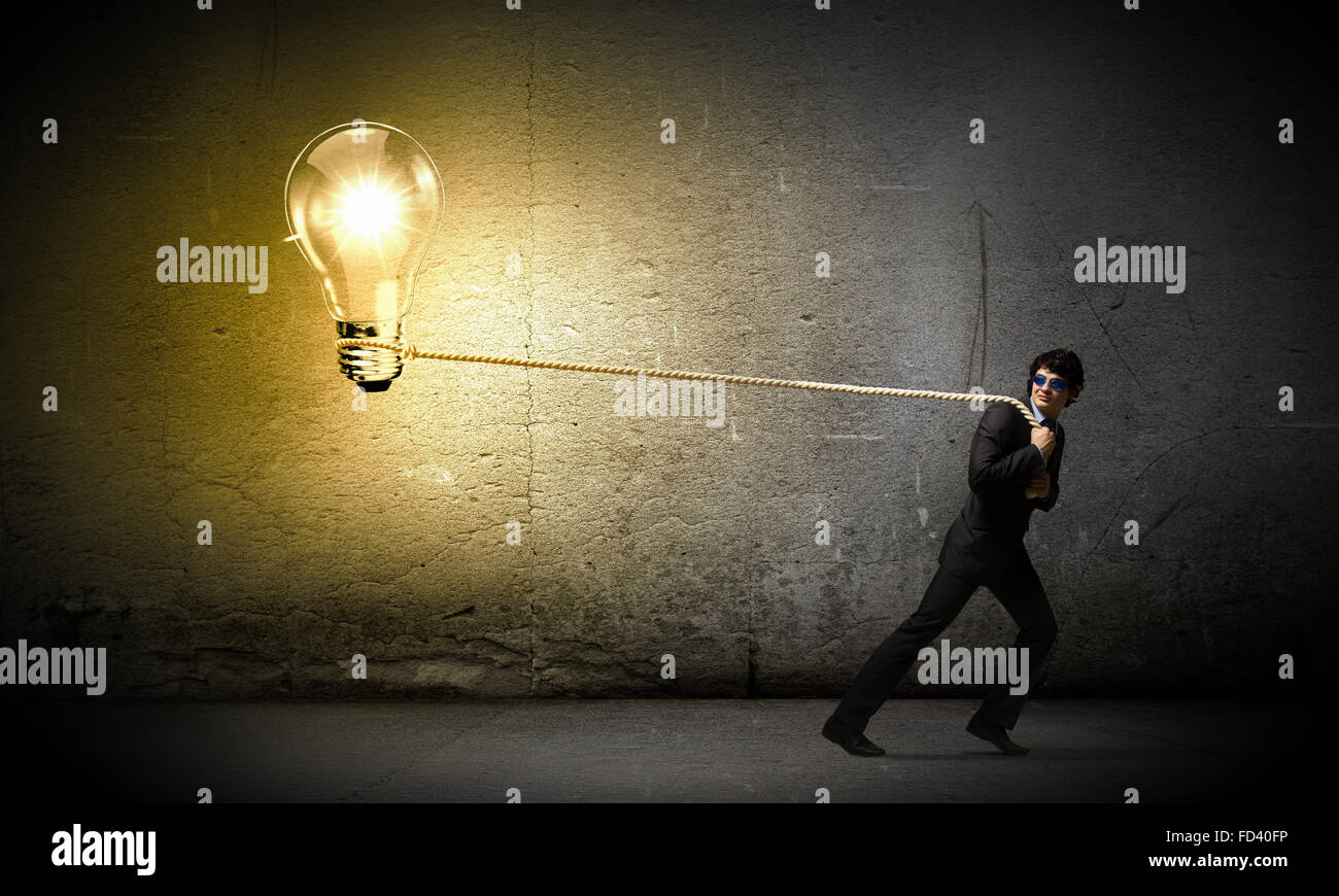 Image of young businessman pulling bulb with rope Stock Photo - Alamy
