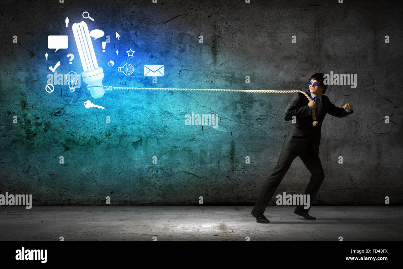 Image of young businessman pulling bulb with rope Stock Photo - Alamy