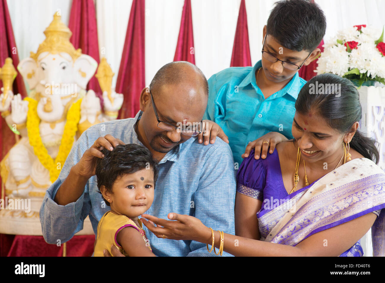 Indian parents and children in a blessing ceremony inside Hindu temple ...