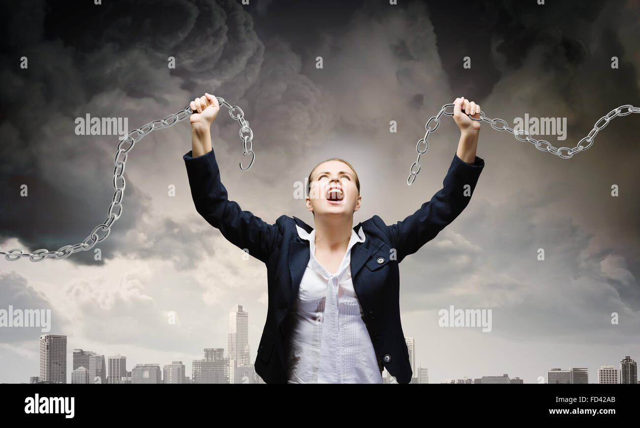 Image of businesswoman in anger breaking metal chain Stock Photo - Alamy