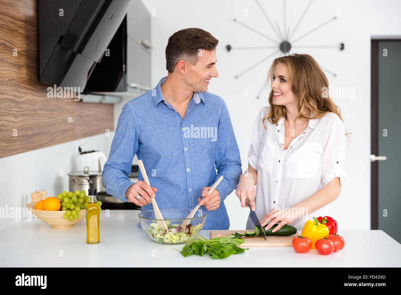 Portrait of a happy beautiful couple cooking together on the kitchen ...