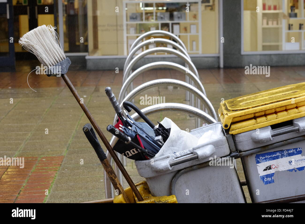road sweepers cart full of ruined umbrellas in shopping precinct ...