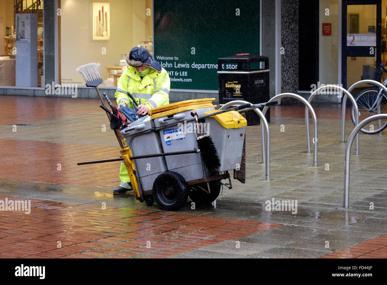 road sweeper with cart full of ruined umbrellas in shopping precinct ...