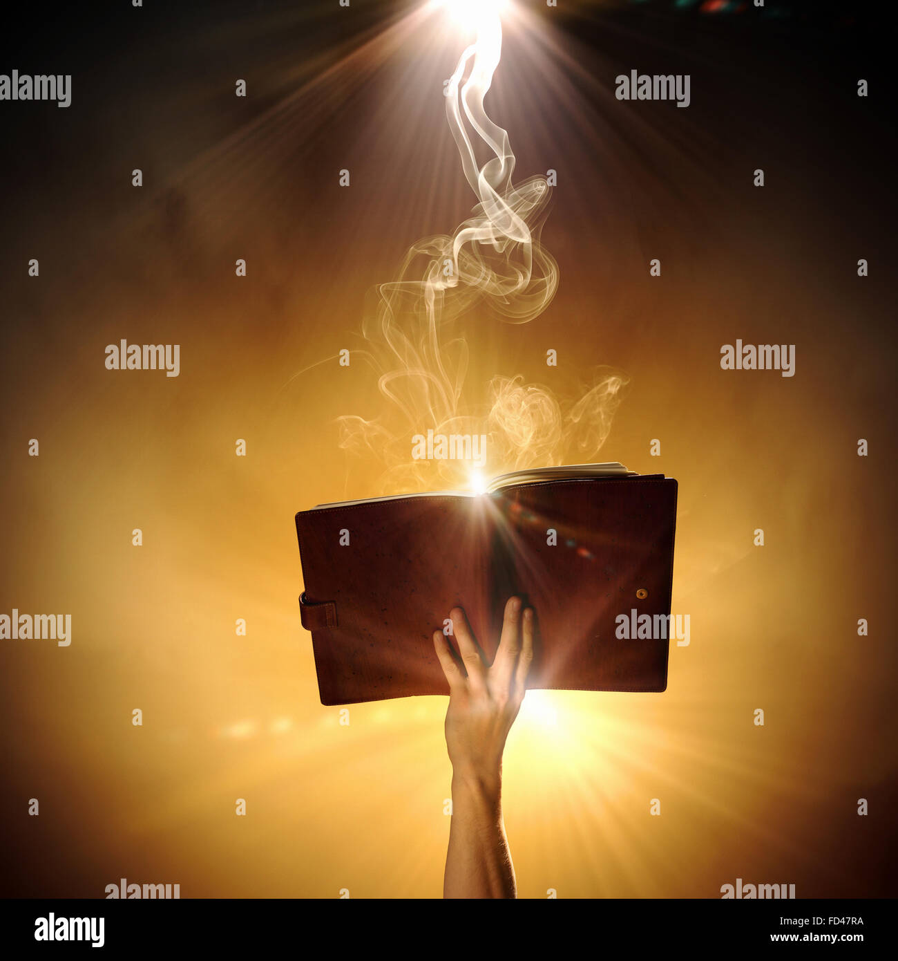 Human hand holding magic book with magic lights Stock Photo - Alamy
