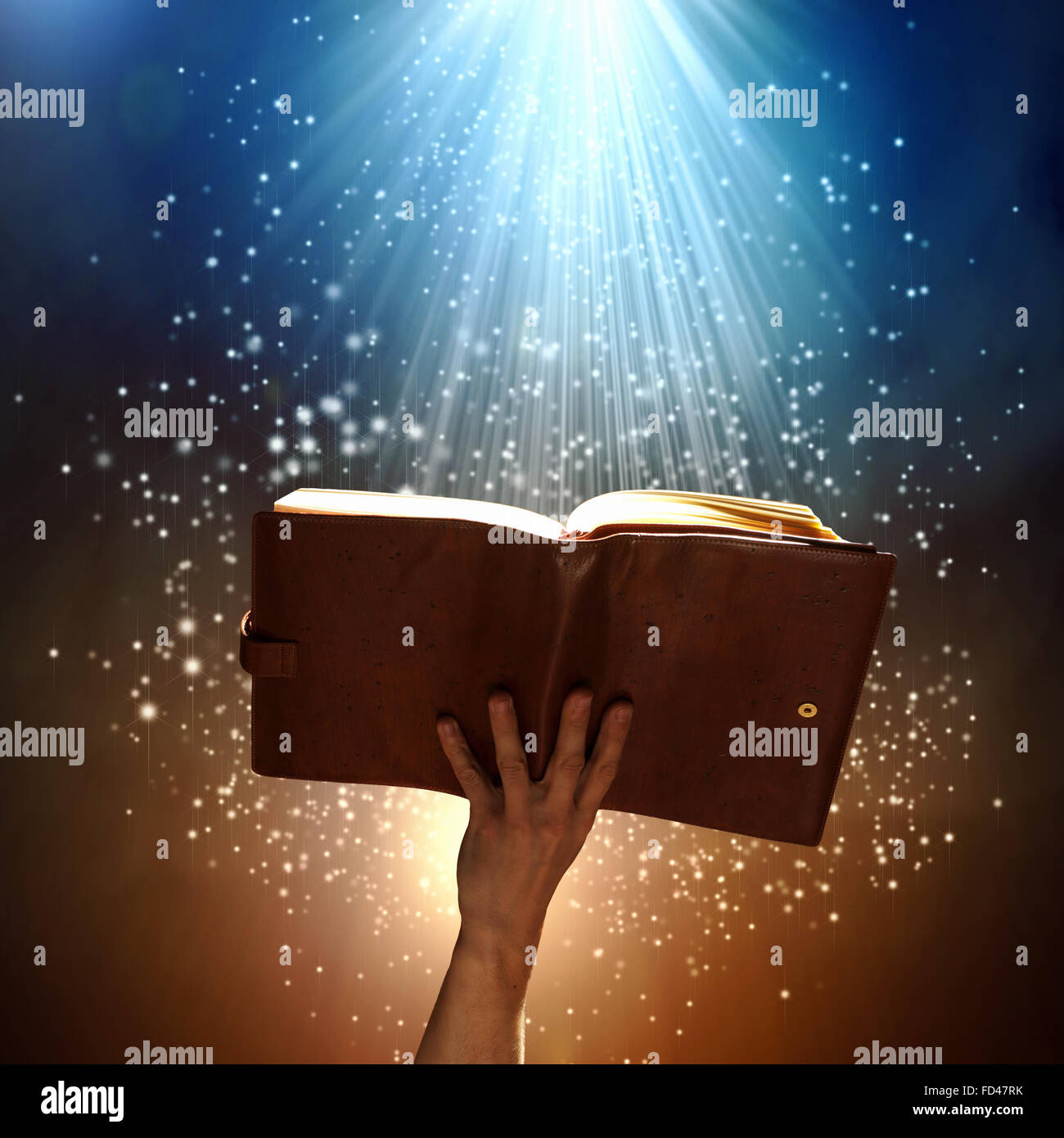 Human hand holding magic book with magic lights Stock Photo - Alamy