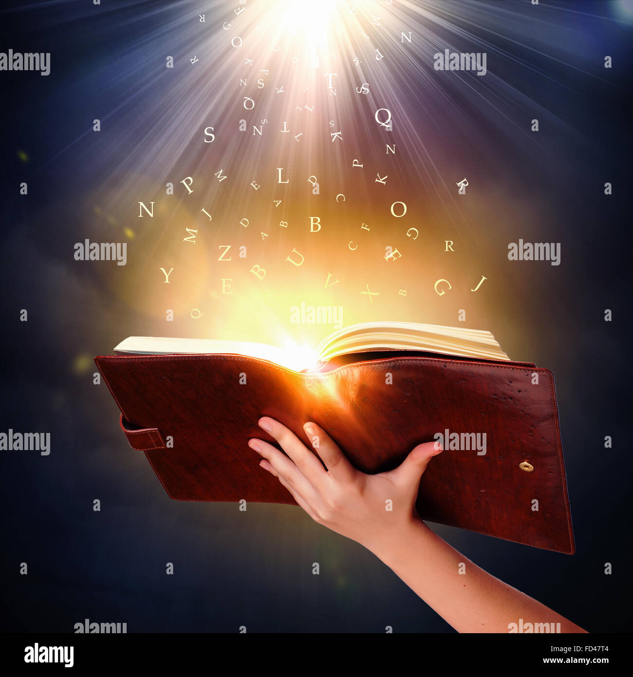 Human hand holding magic book with magic lights Stock Photo - Alamy