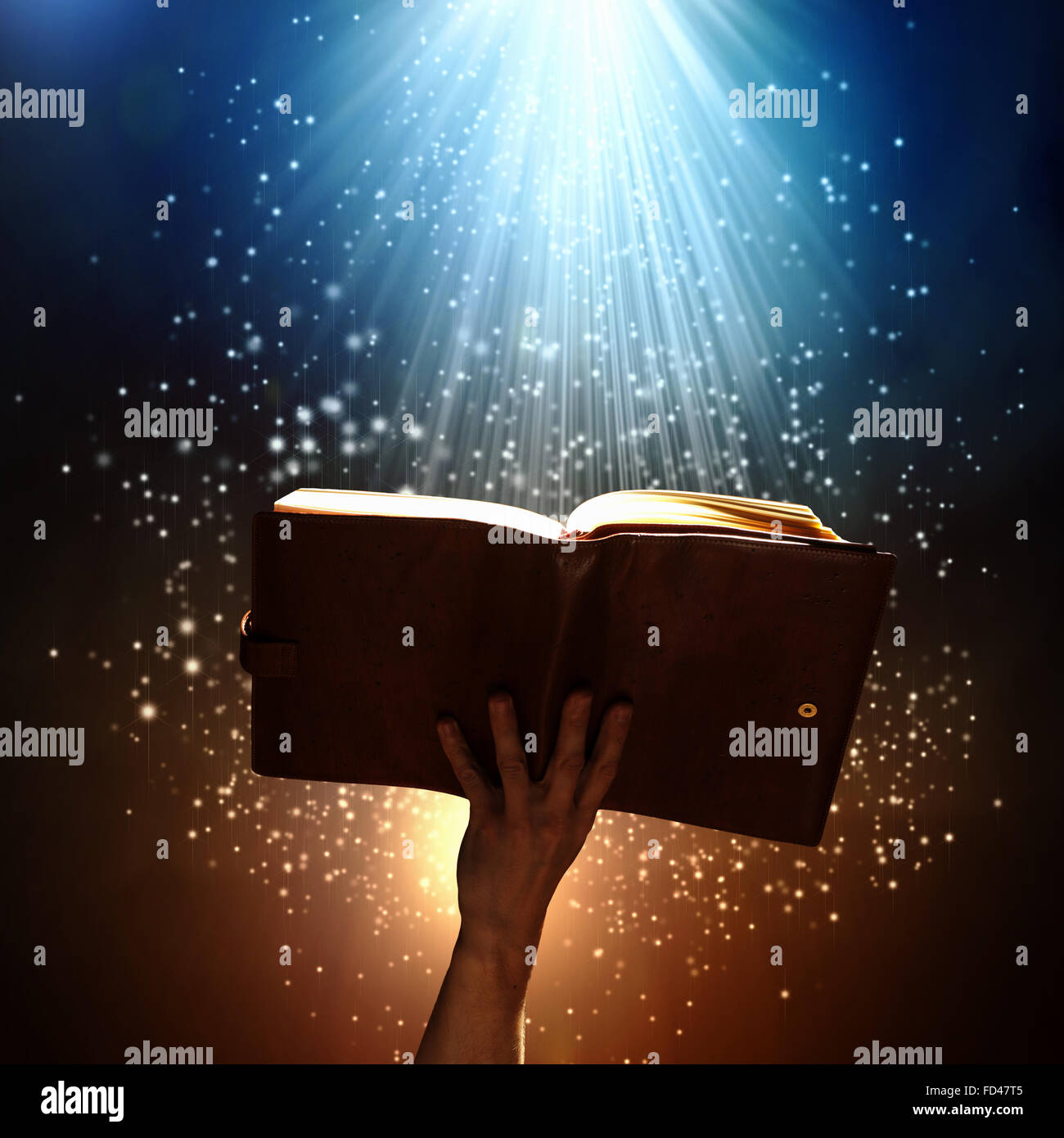 Human hand holding magic book with magic lights Stock Photo - Alamy