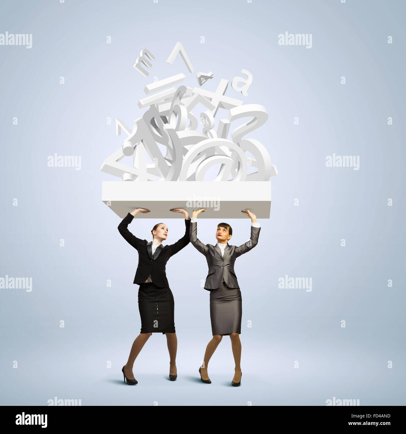 Image of two businesswomen holding burden above head Stock Photo - Alamy