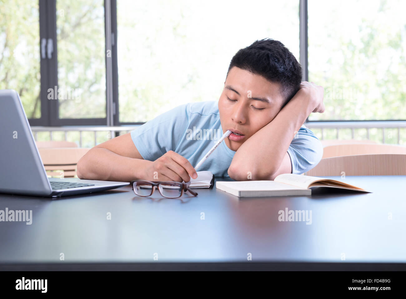 College student falling asleep in library Stock Photo - Alamy