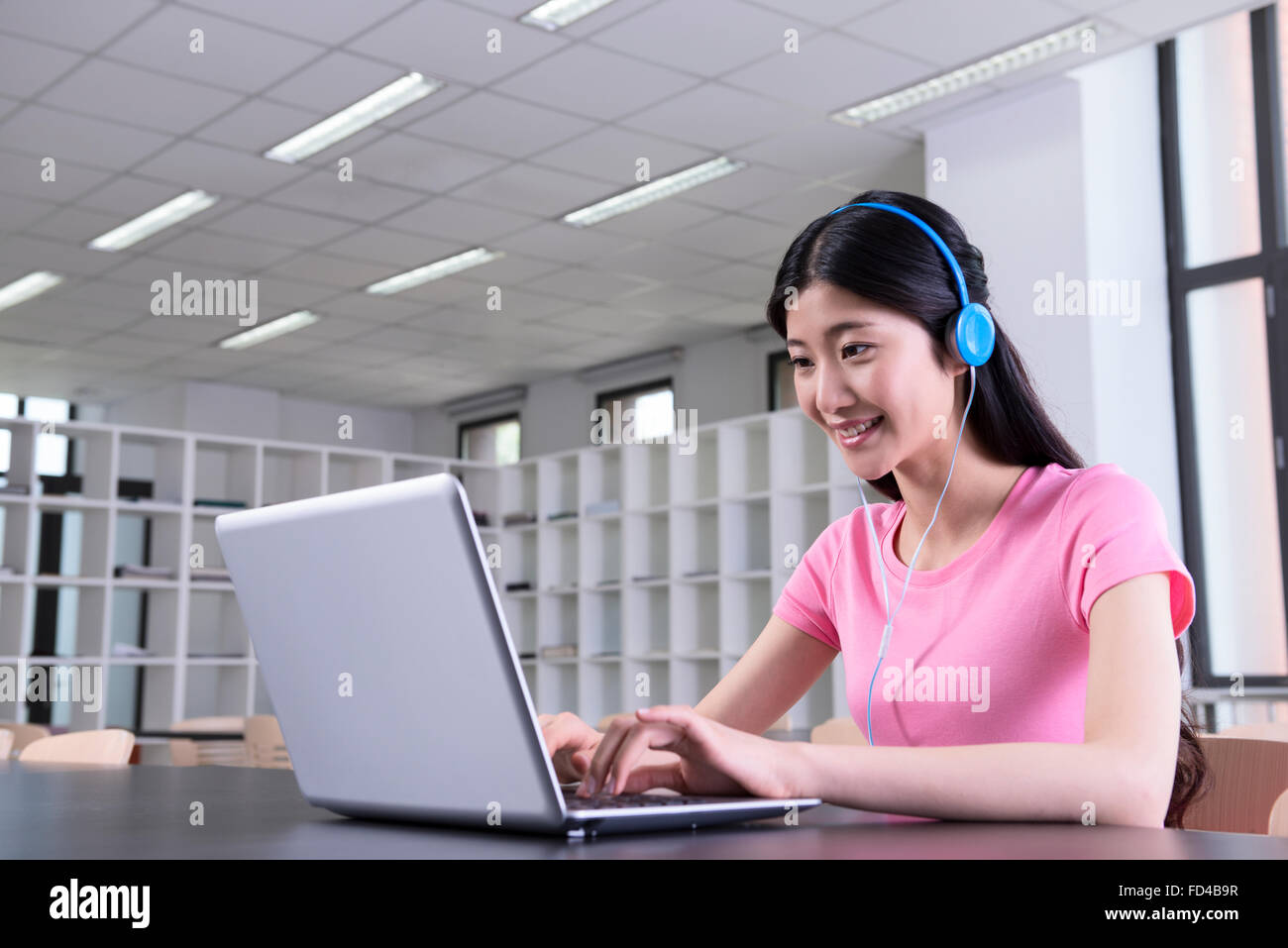 College student using laptop in library Stock Photo - Alamy