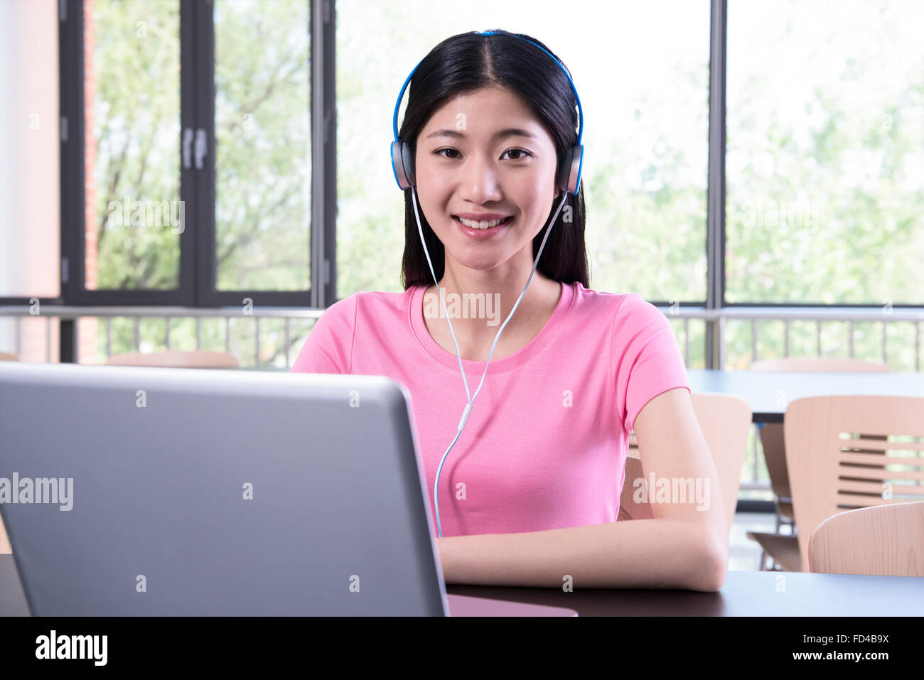 College student using laptop in library Stock Photo - Alamy