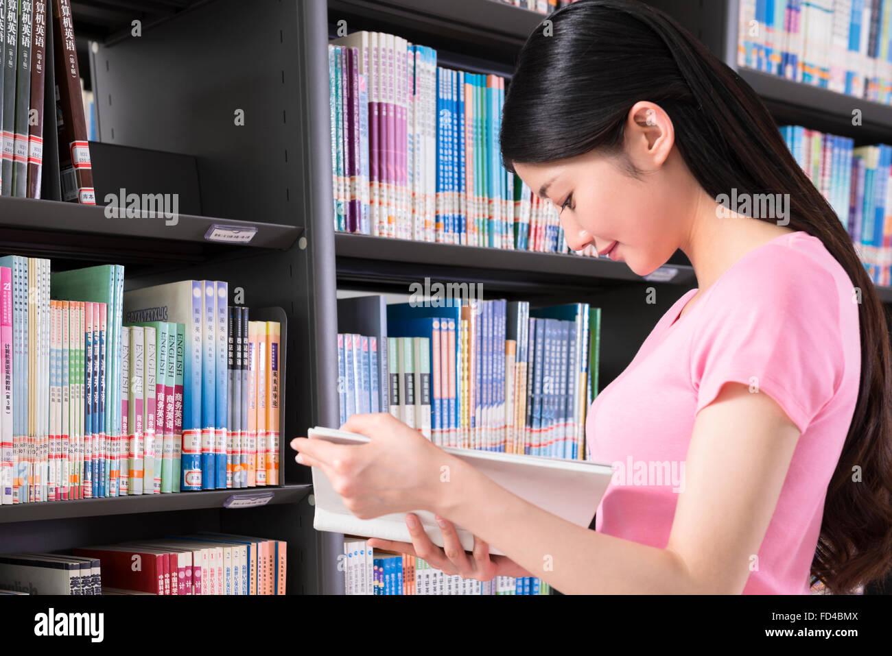 College student reading in library Stock Photo - Alamy