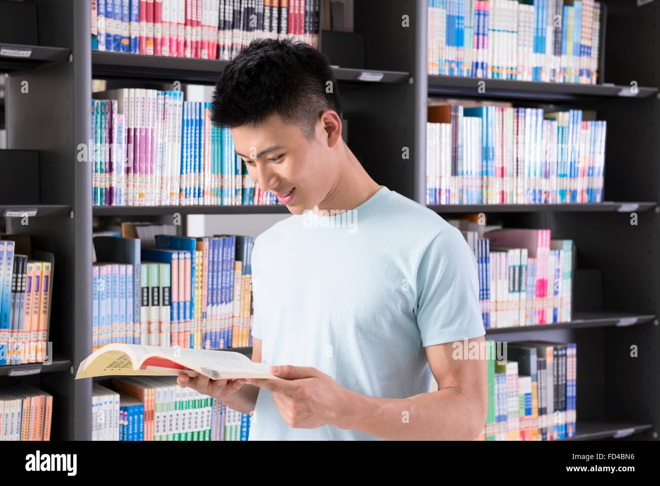 College student reading in library Stock Photo - Alamy