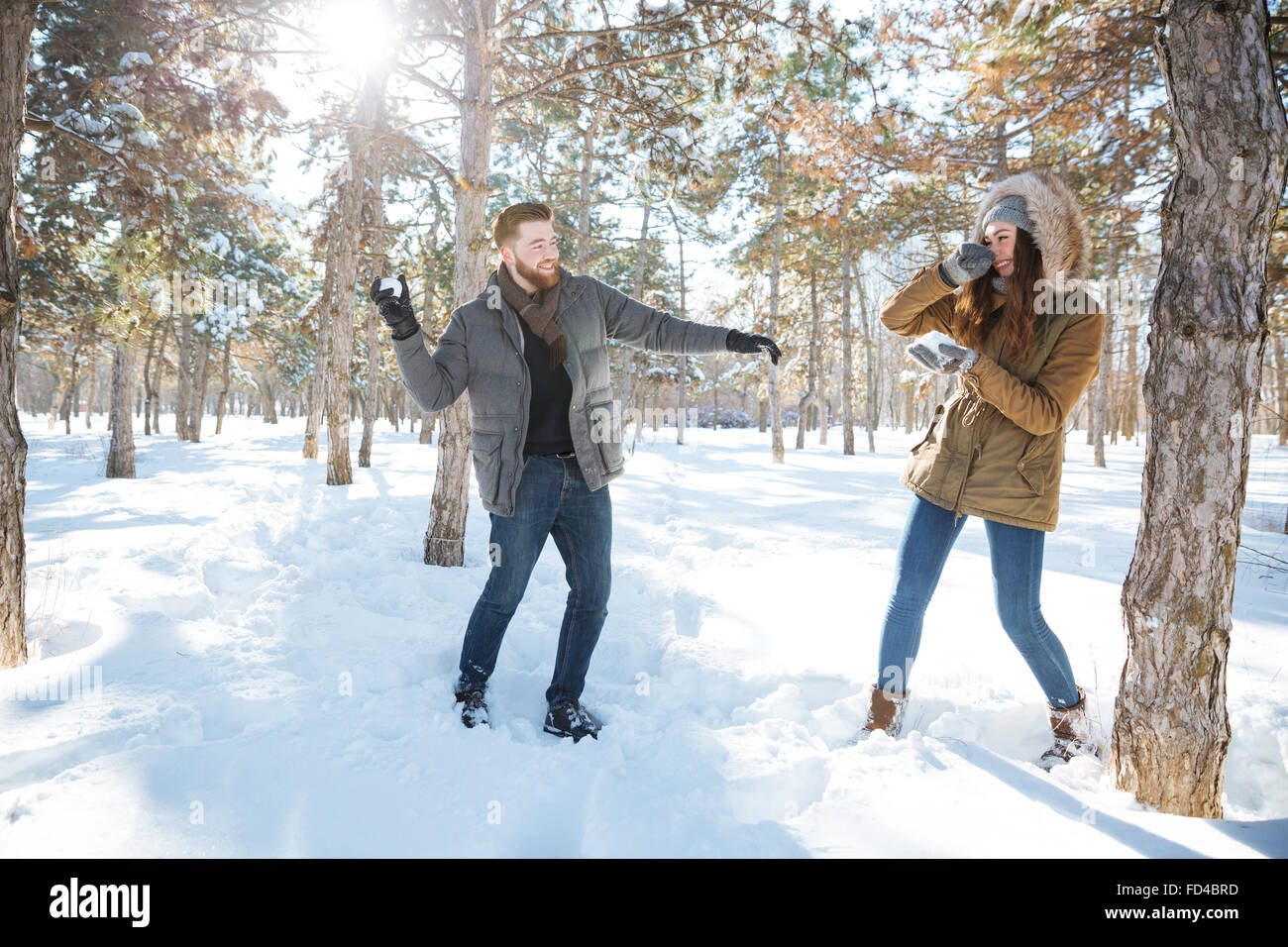 Happy couple playing with snow in winter park. Snowball fight Stock ...