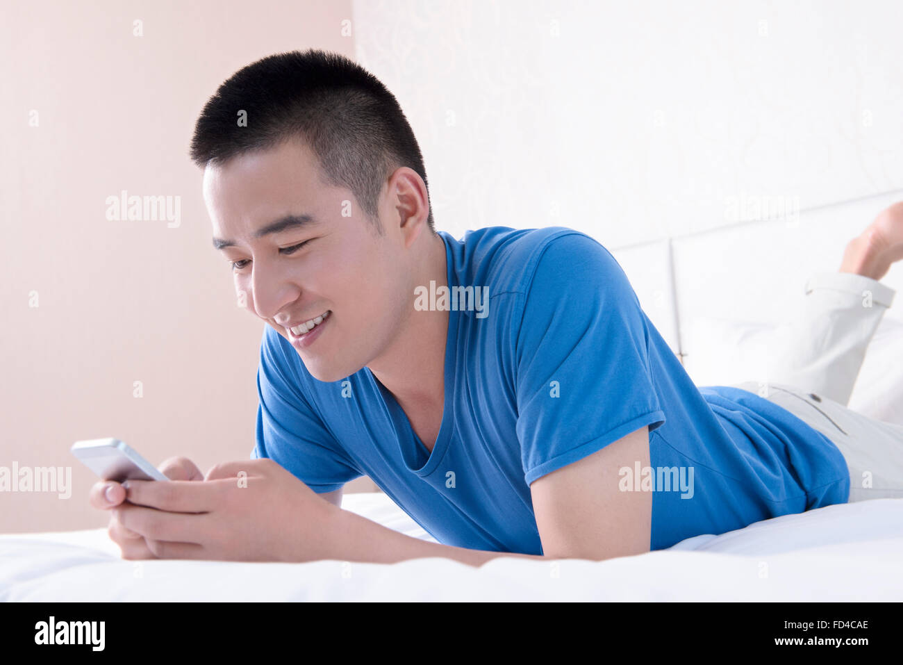 Young man using smart phone in bed Stock Photo - Alamy