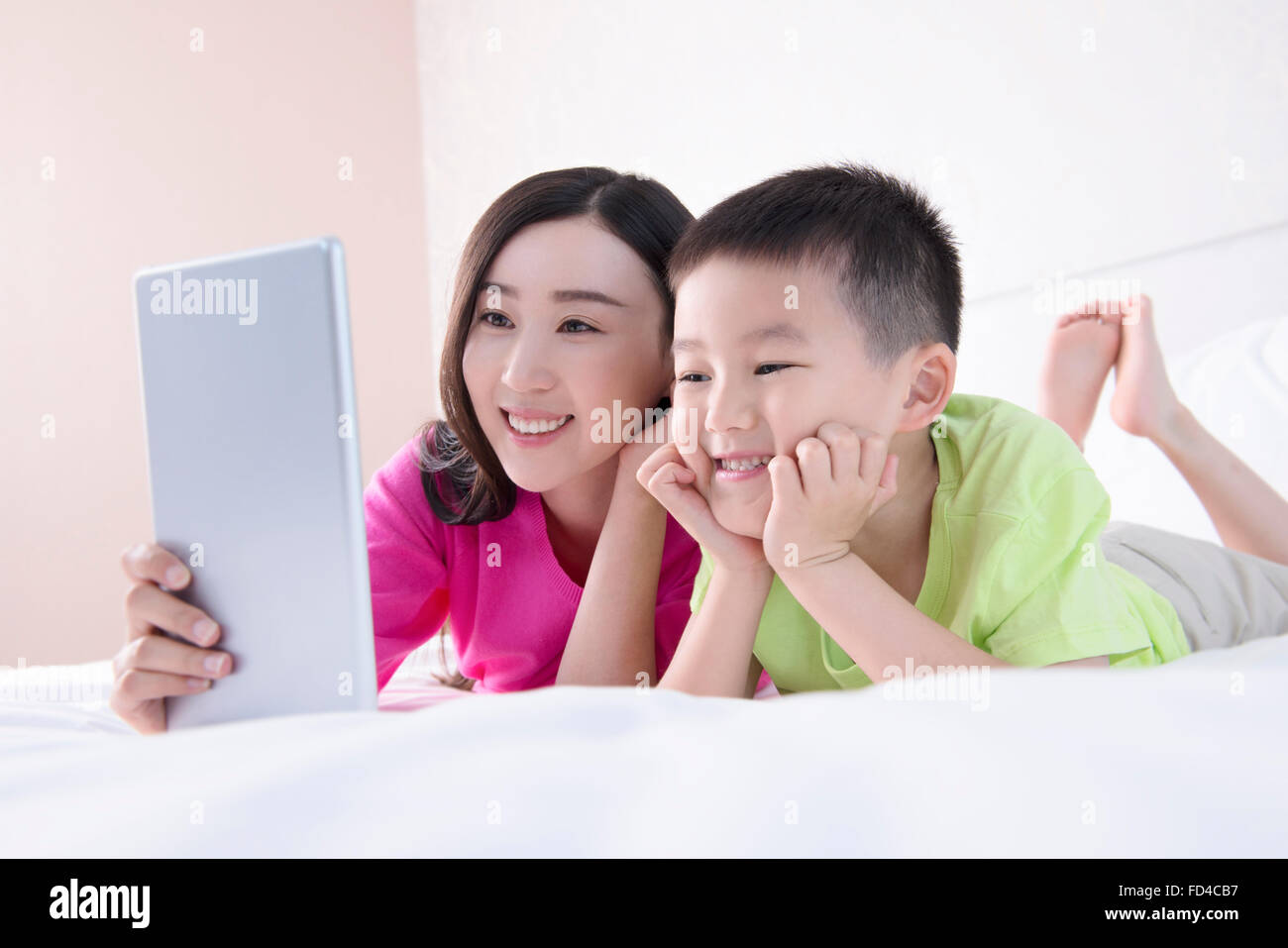 Mother and son using digital tablet in bed Stock Photo - Alamy