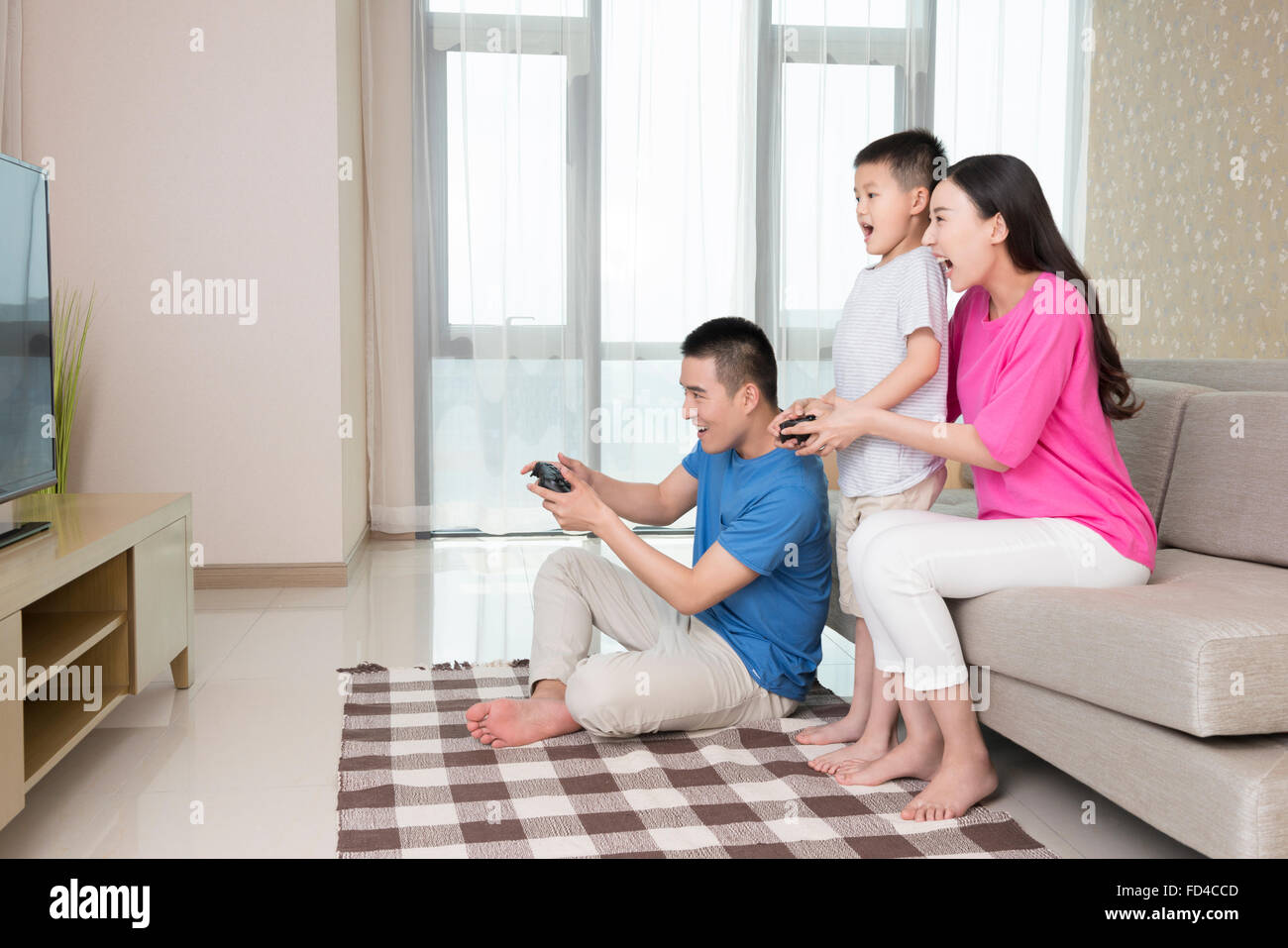 Young family playing video game Stock Photo - Alamy