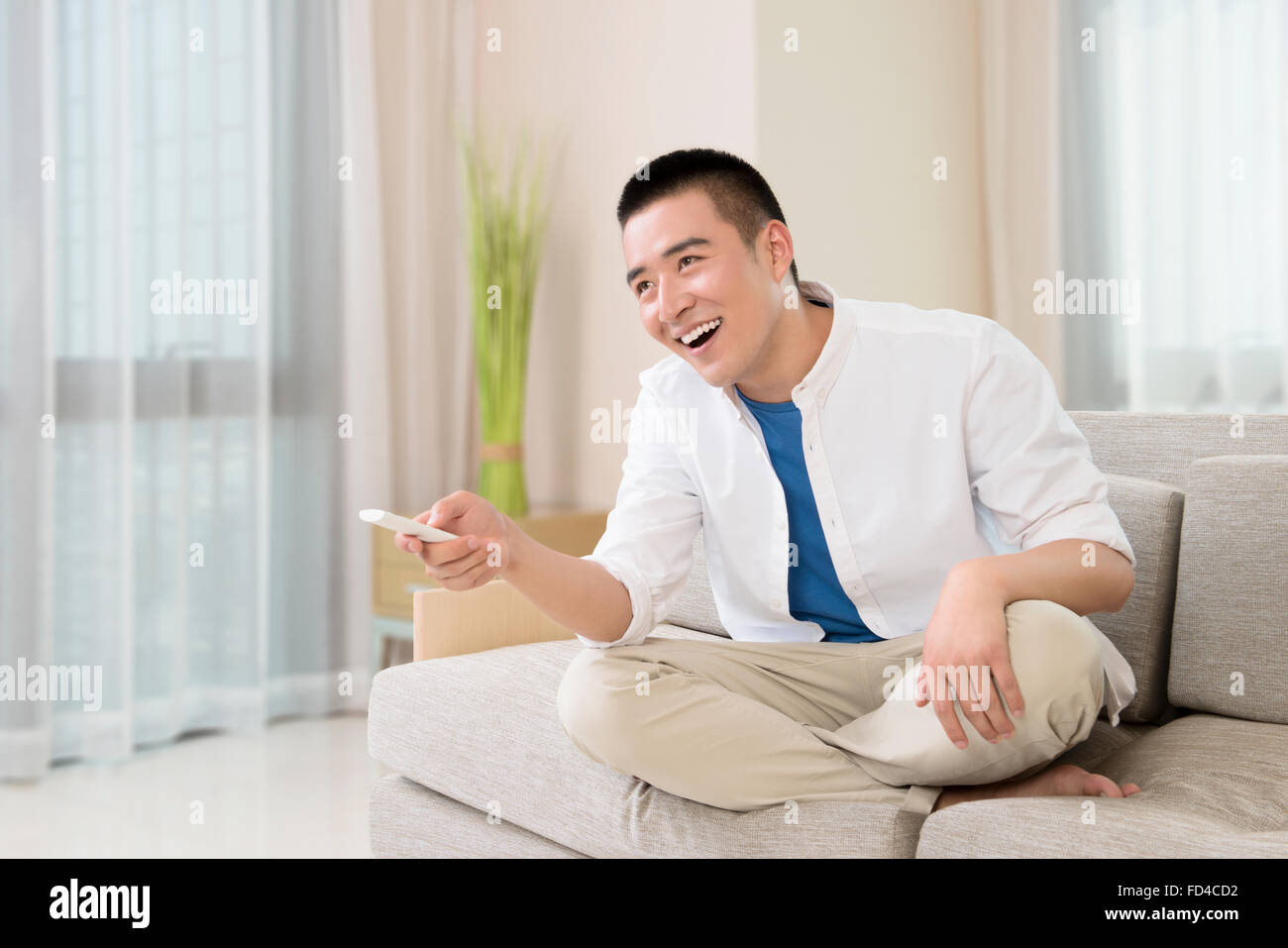 Young man watching TV Stock Photo - Alamy
