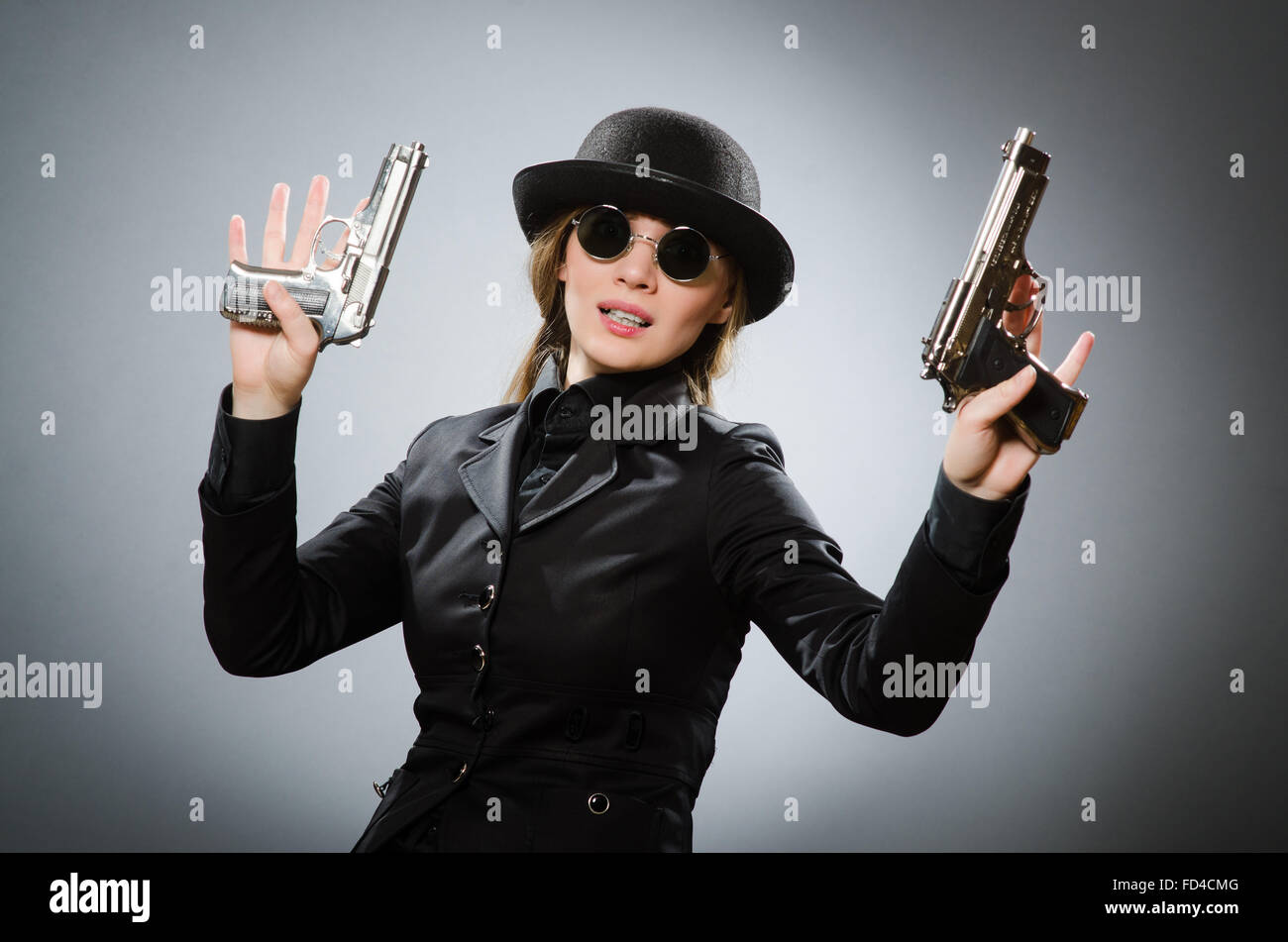 The female spy with weapon against gray Stock Photo - Alamy