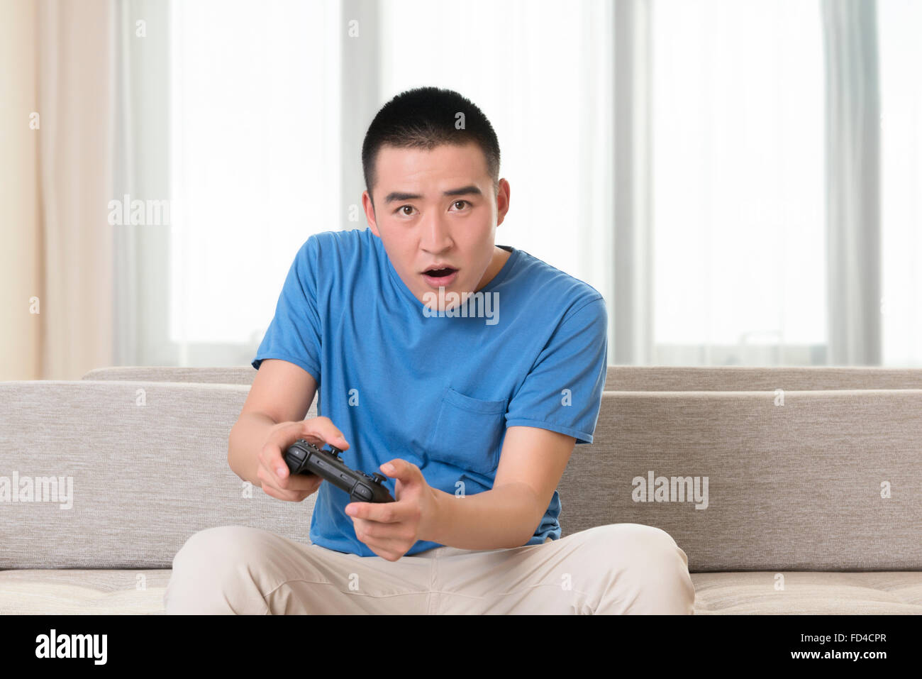 Young man playing video games Stock Photo - Alamy