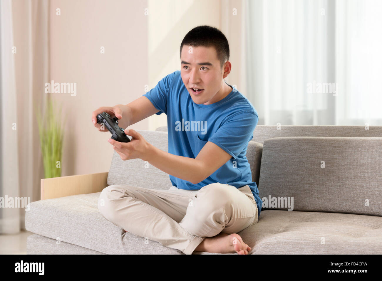 Young man playing video games Stock Photo - Alamy