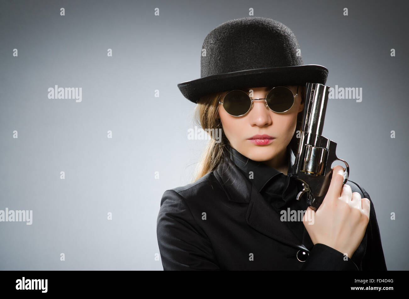 The female spy with weapon against gray Stock Photo - Alamy