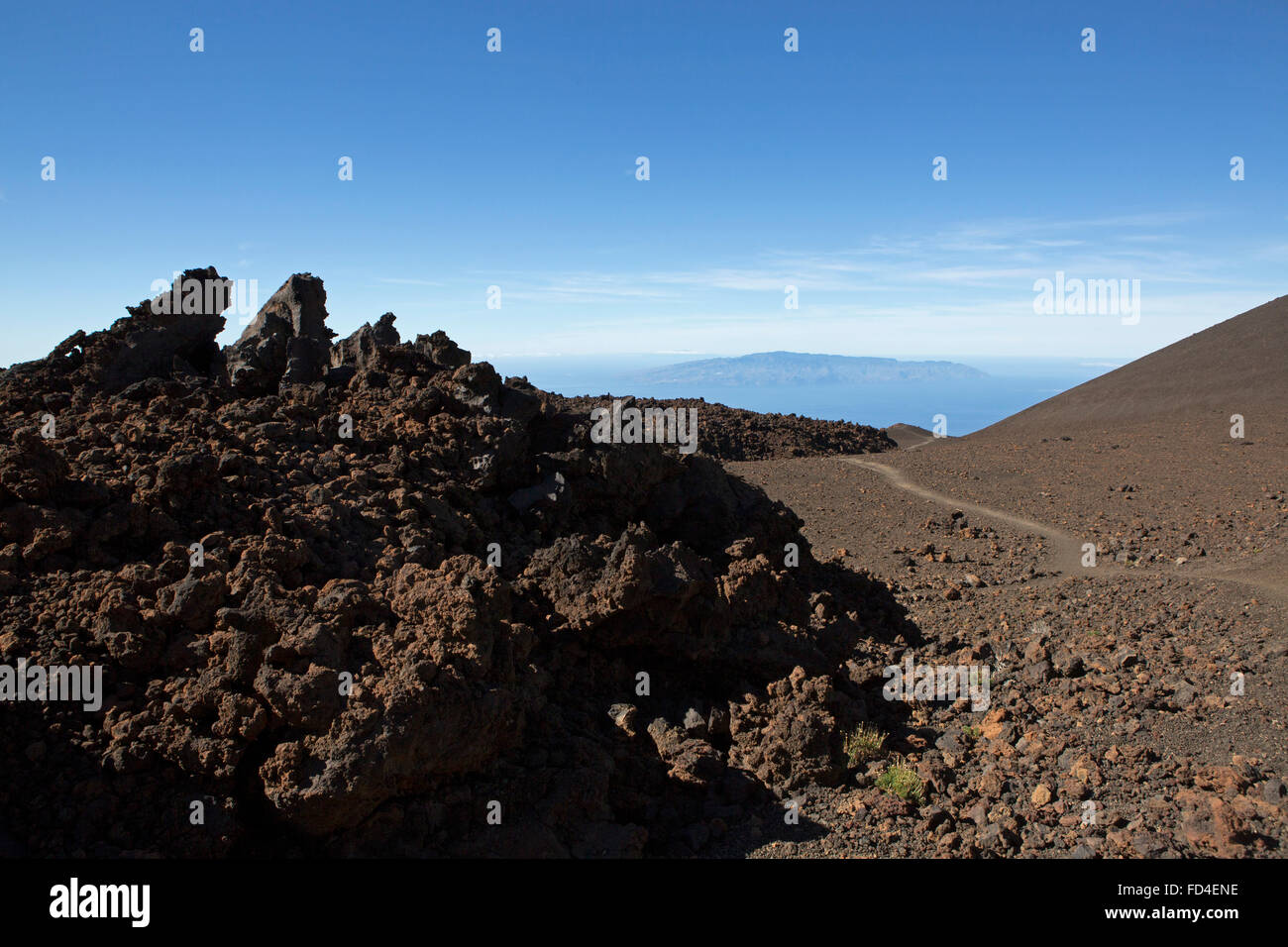A walking trail snakes through volcanic rock on the Samara Volcano in ...