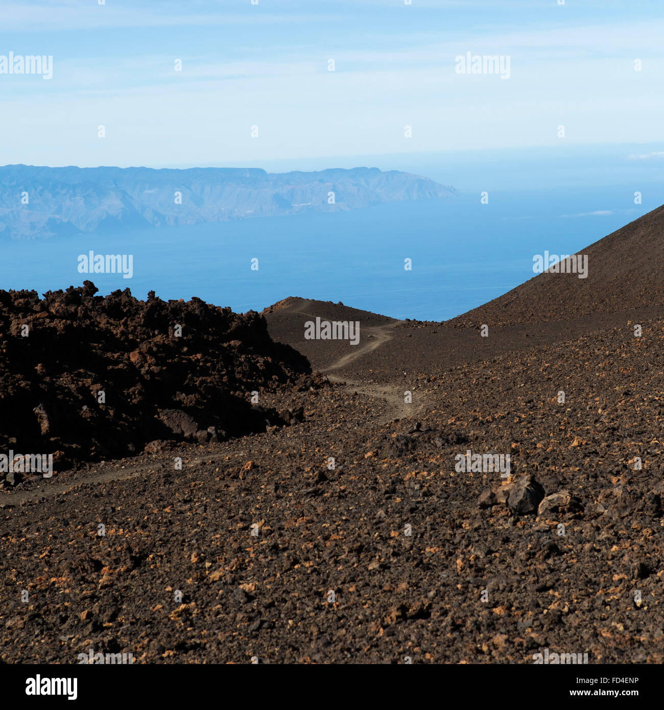 A walking trail snakes through volcanic rock on the Samara Volcano in ...