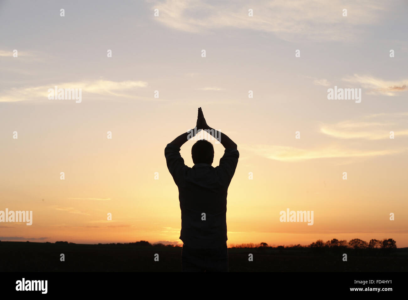 Silhouette of a man praying at sunset Stock Photo - Alamy