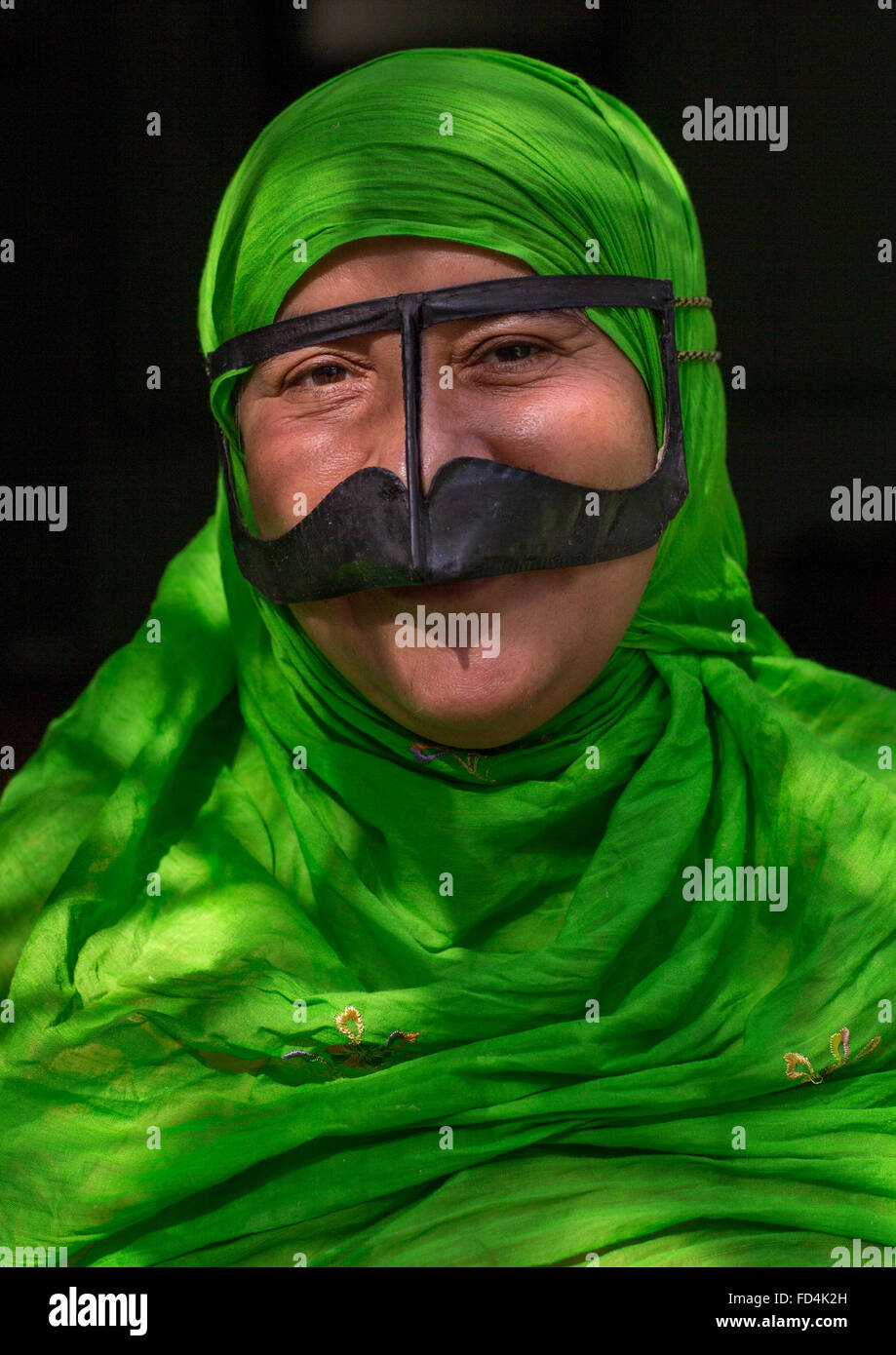 a bandari woman wearing a traditional mask called the burqa with a ...