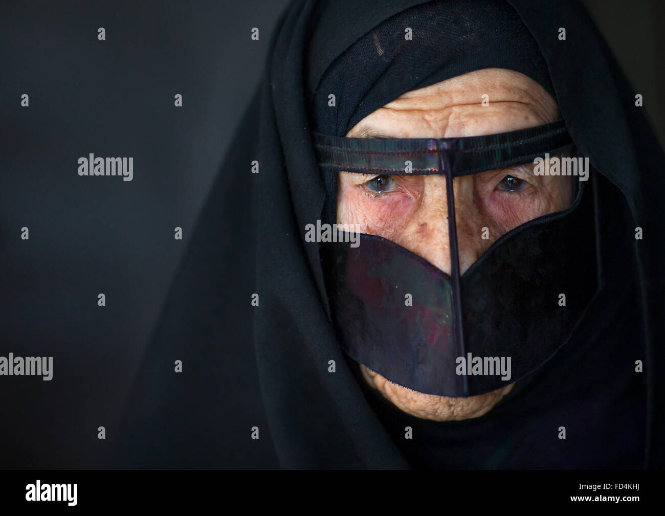 an old bandari woman wearing a traditional mask called the burqa, Qeshm ...