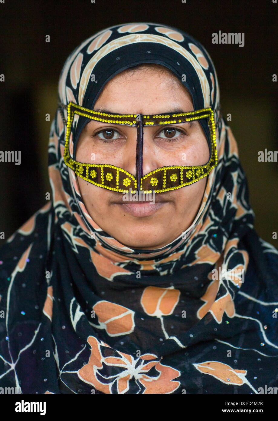 a bandari woman wearing a traditional mask called the burqa with a ...