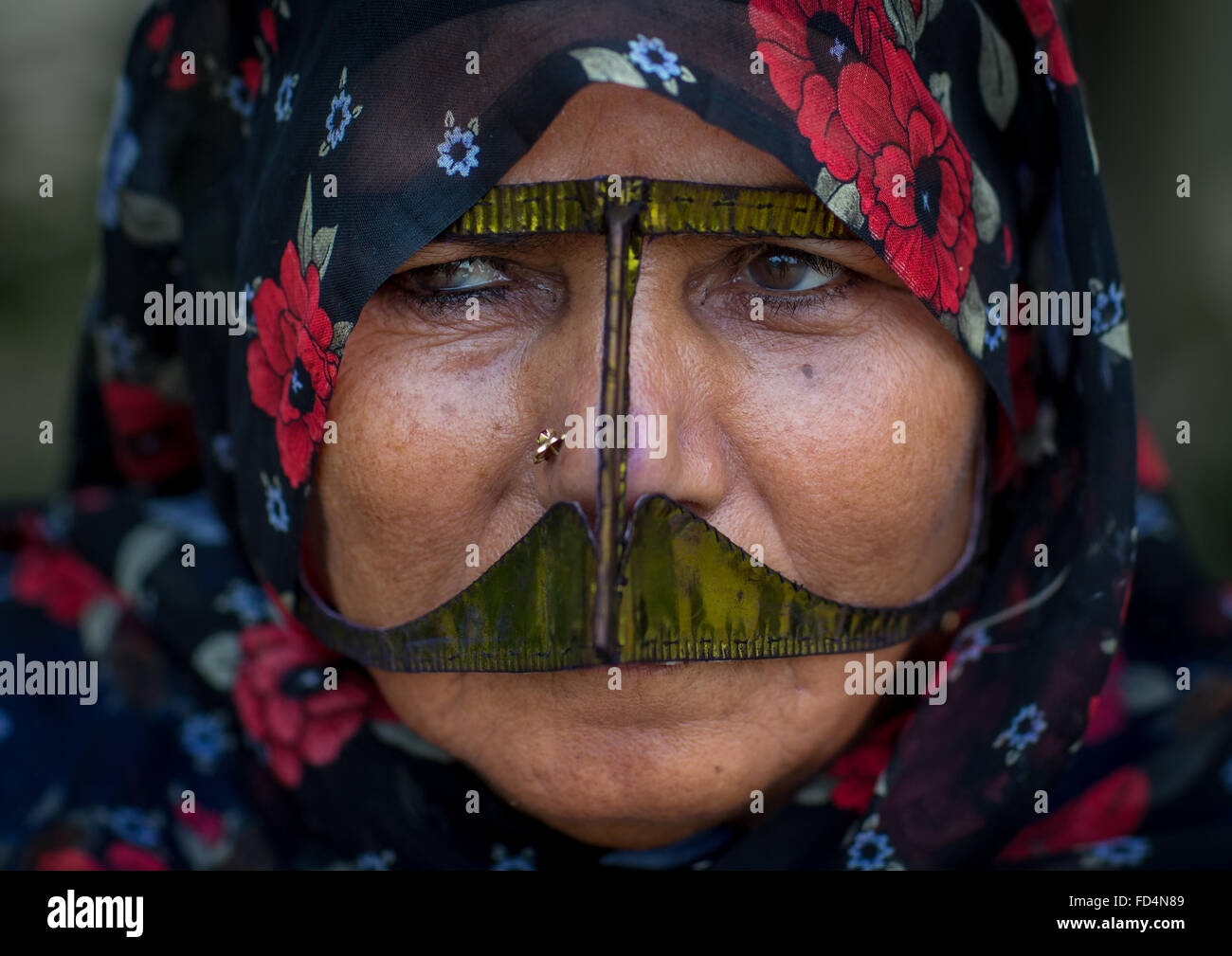 a bandari woman wearing a traditional mask called the burqa with a ...
