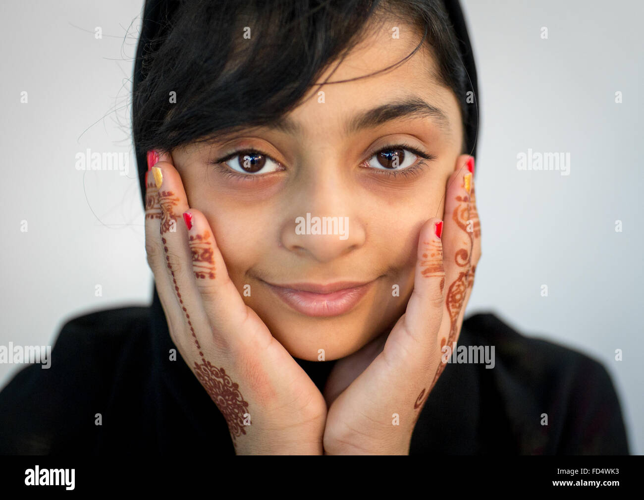 portrait of a young girl with henna tattooed hands in traditional ...