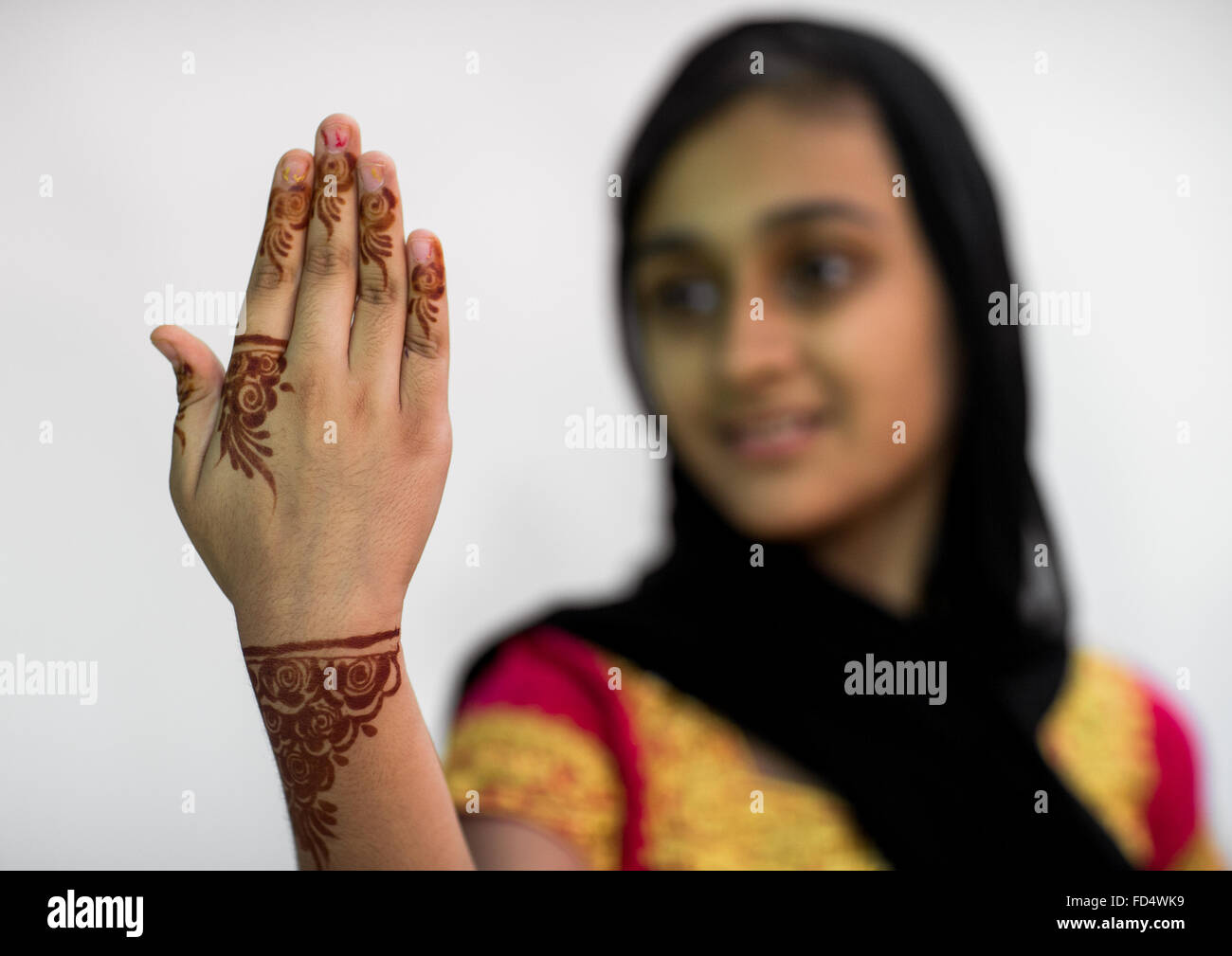 portrait of a young girl with henna tattooed hand in traditional ...