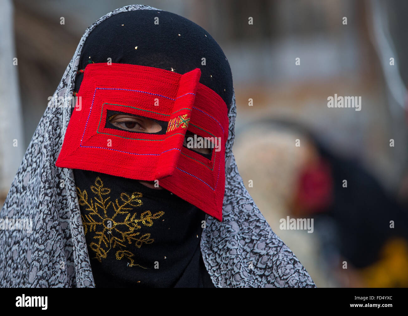 a bandari woman wearing a traditional mask called the burqa at ...