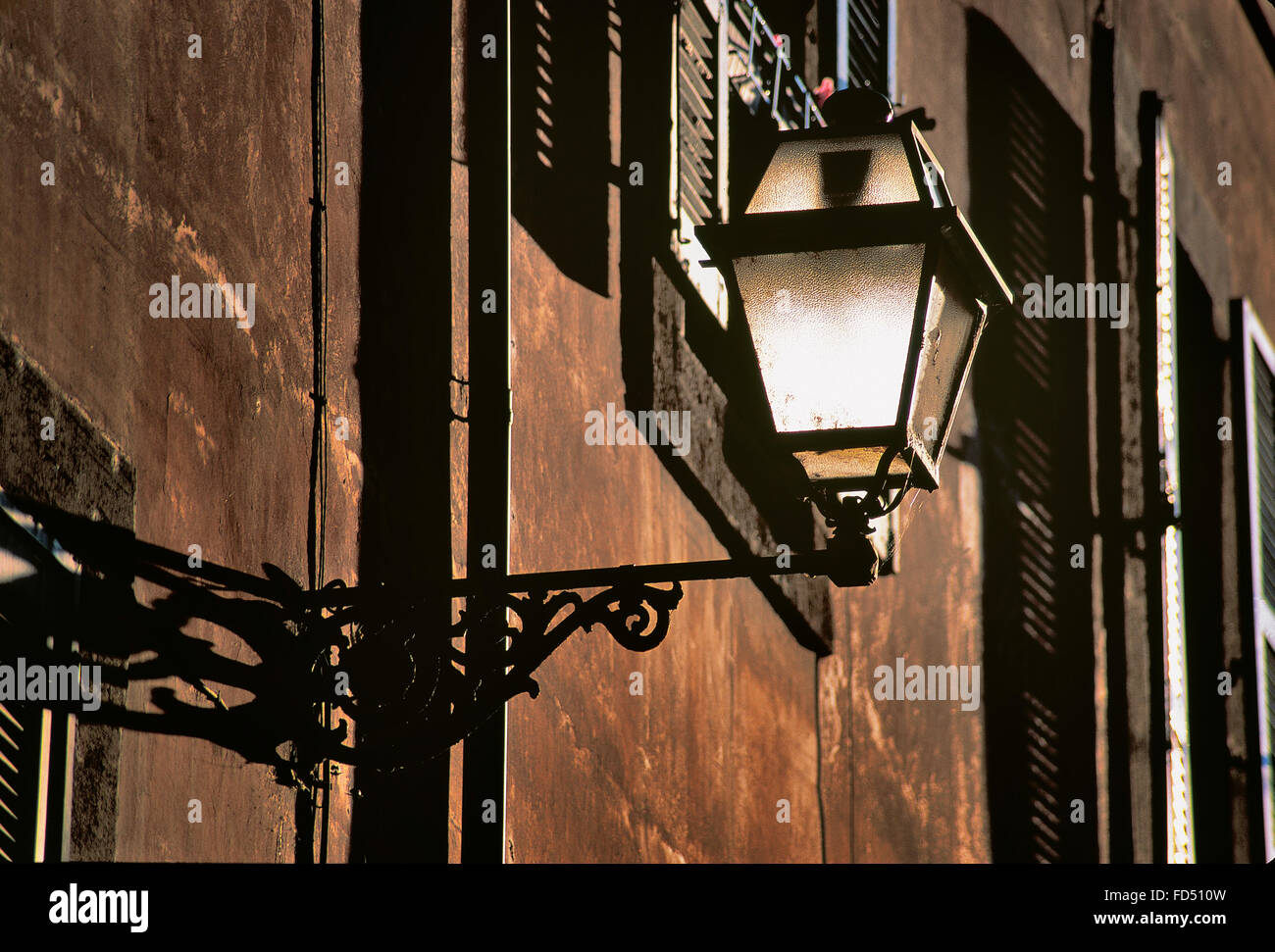 Brown Roman wall with street lamp and windows at golden hour Stock ...