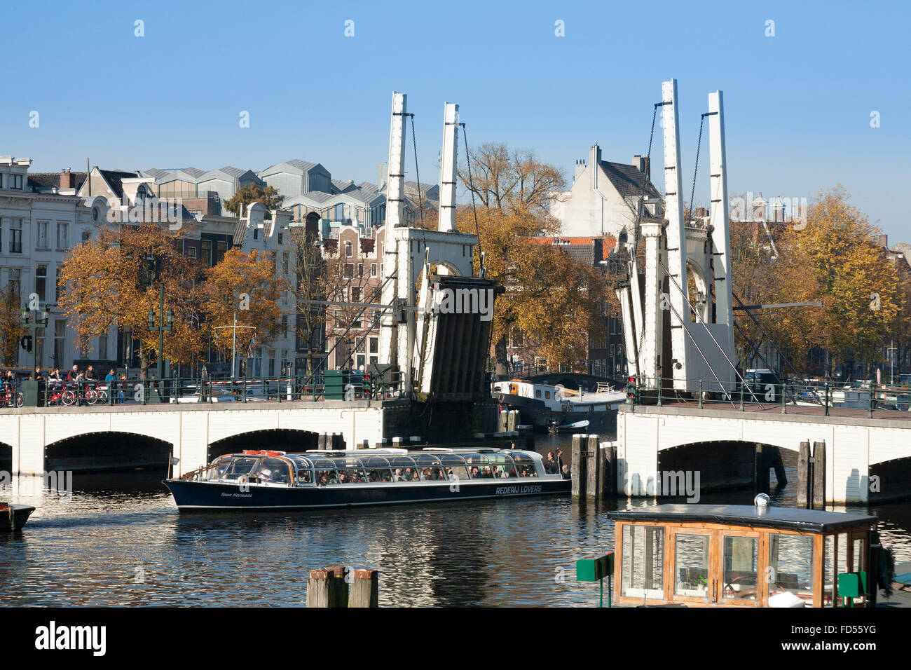 Tourist boat / barge passes under the Magere Brug ('Skinny Bridge') in ...